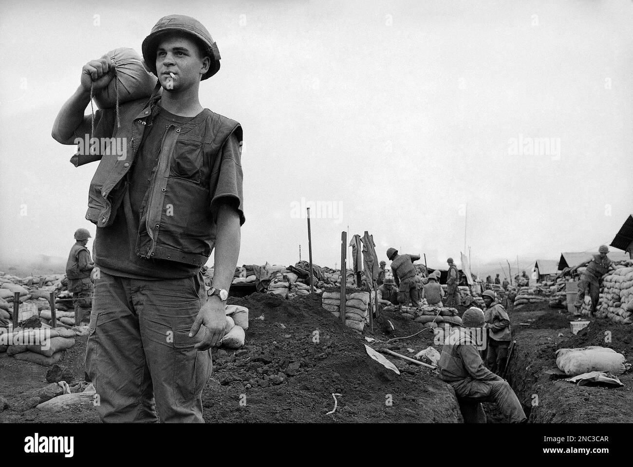 Lance Cpl. Richard Moyes, 19, of Cincinnati, Ohio, totes a sack of sand ...