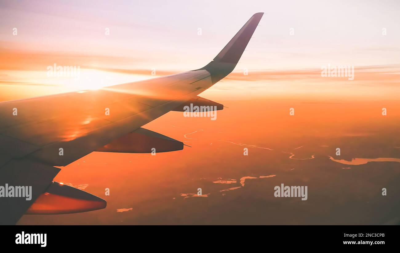 In plane flight view from window with stunning sunset background and ...