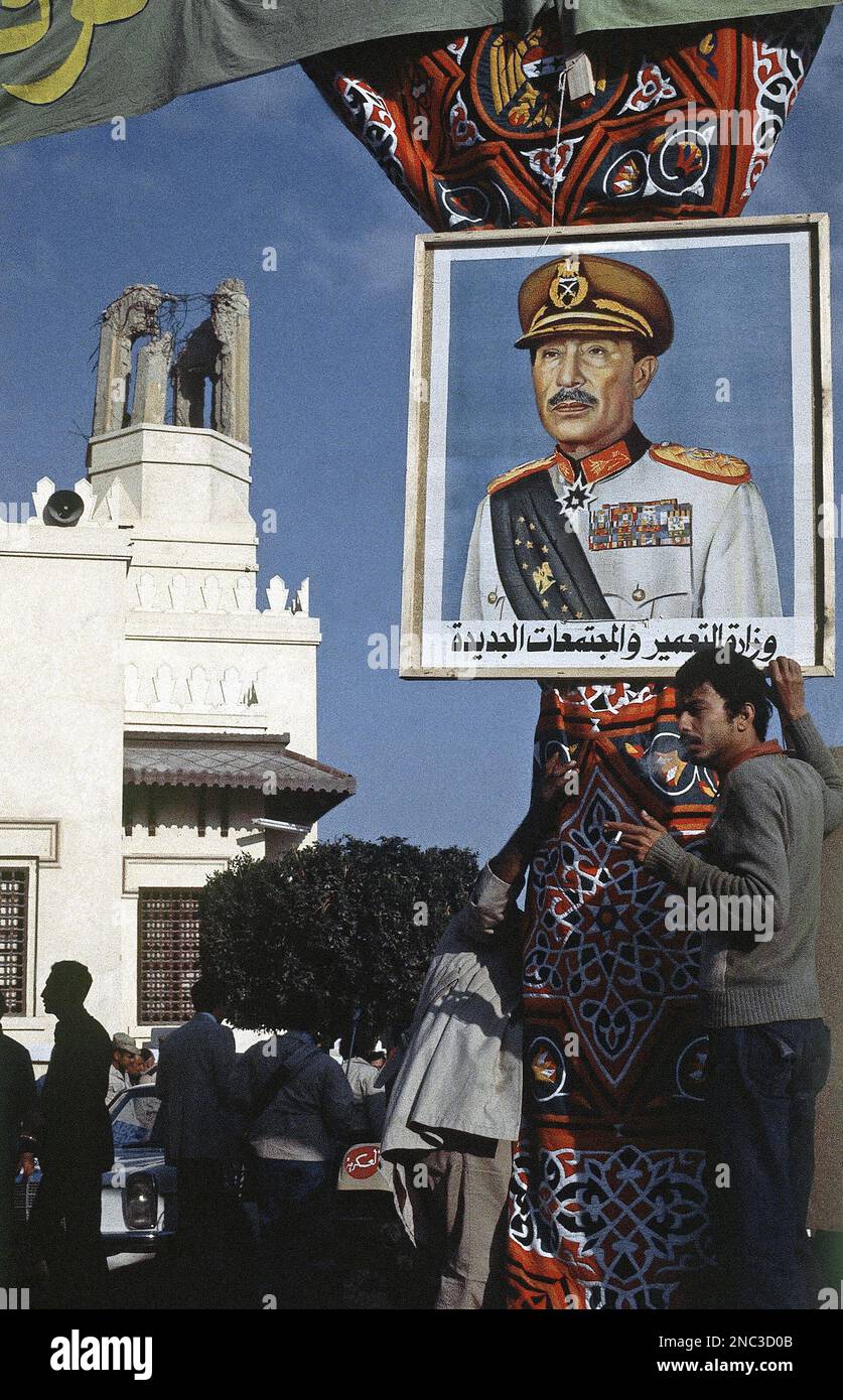 A portrait of President Anwar Sadat is hung on a street near the Al ...