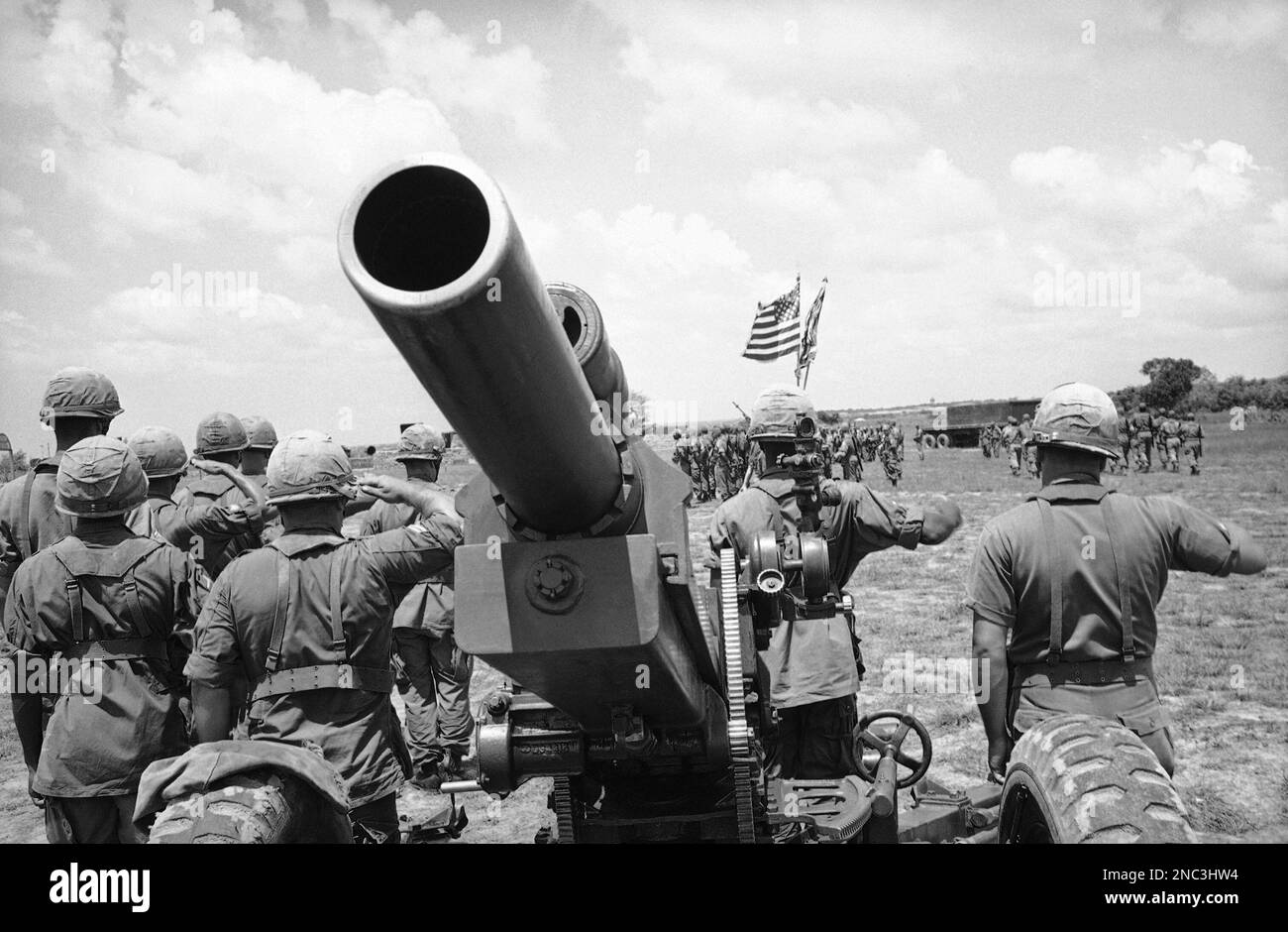 The mouth of a 105mm howitzer dominates the foreground with the ...