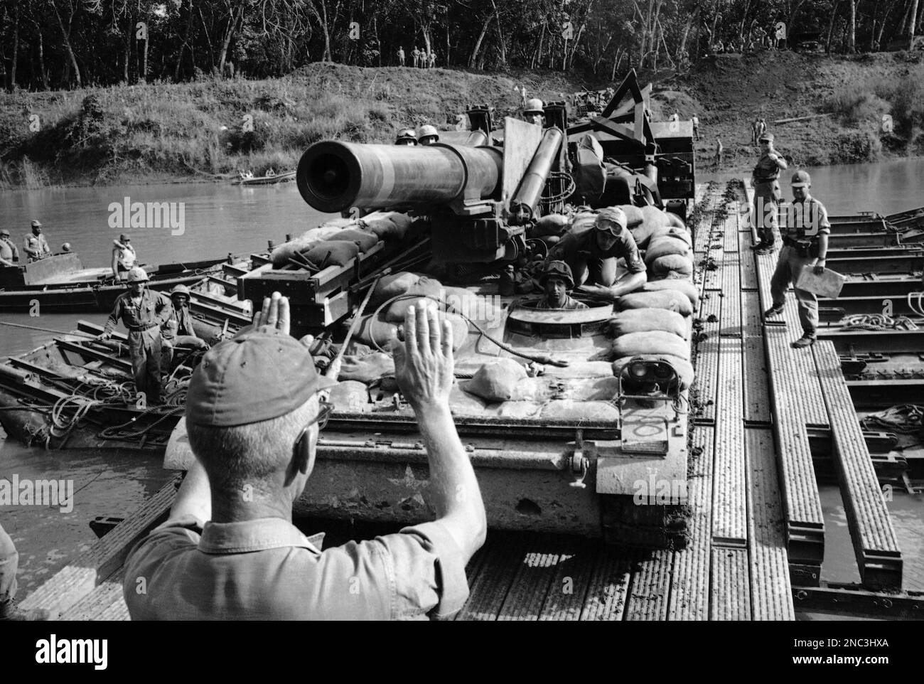 A U.S. Army engineer uses hand signals to help the driver of a self ...