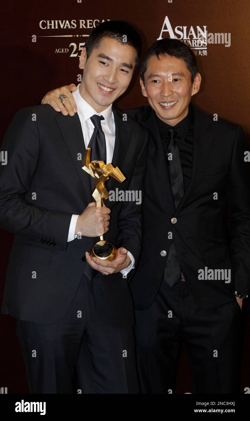 Taiwan actor Mark Chao Yu-Ting, left, holding the trophy is greeted by ...