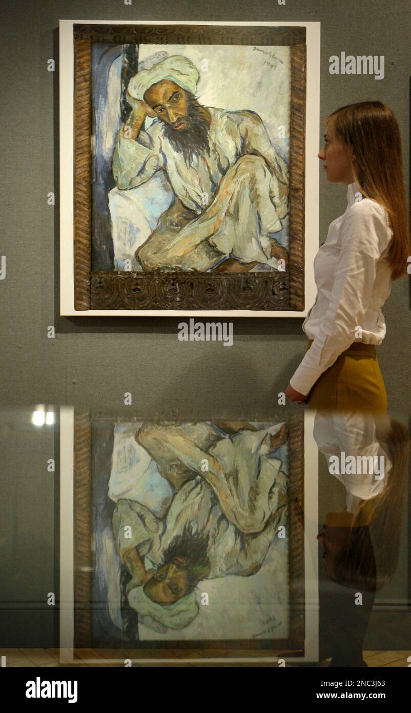 A Bonhams employee poses with a reproduction of a painting 'Arab Priest ...