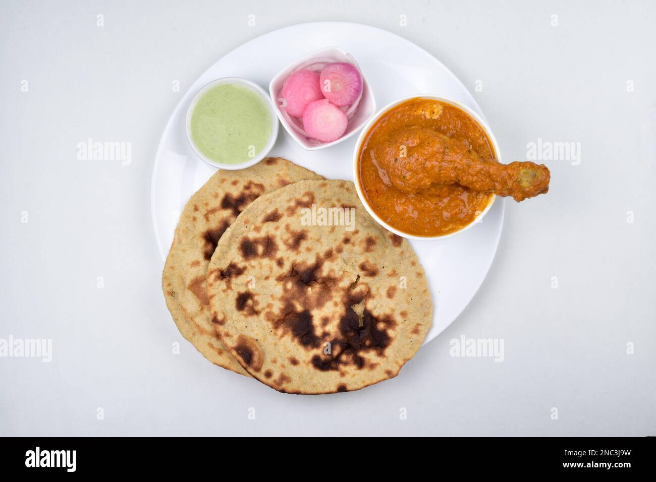 Butter chicken with tandoori roti served with chutney onion on white ...