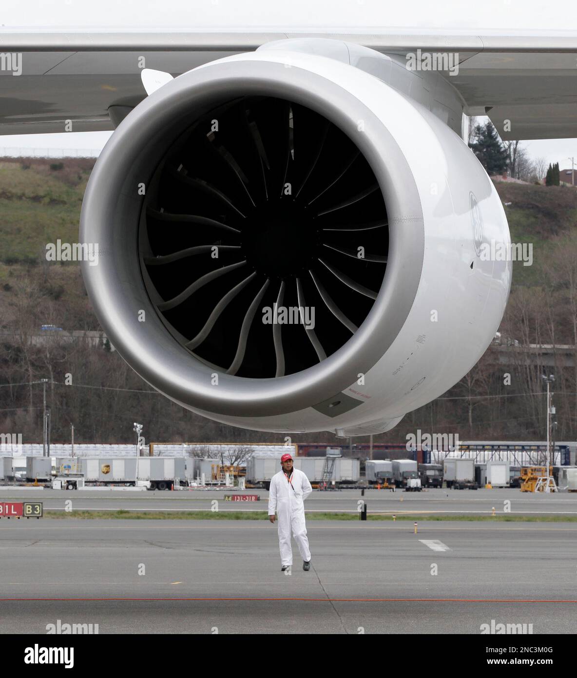 A worker stands behind one of the four engines on Boeing Co.'s new 747 ...