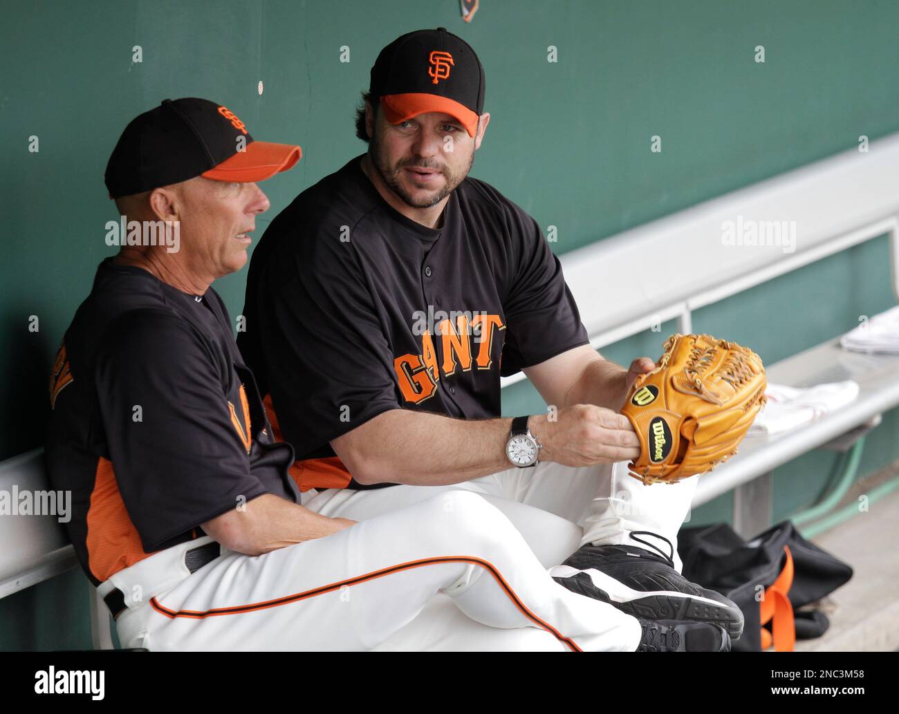 San Francisco Giants third base coach Tim Flannery, left, visits with ...