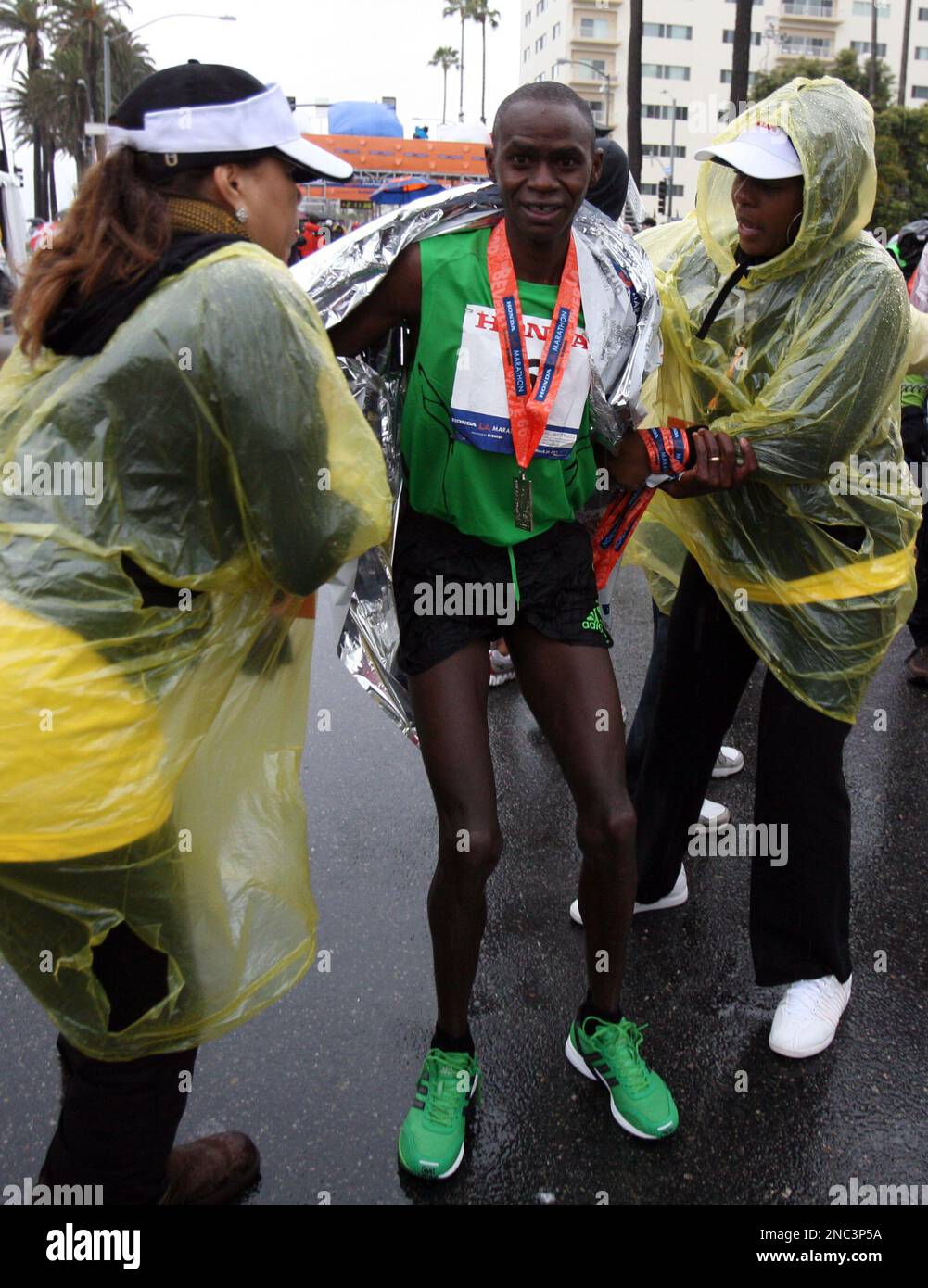 A runner is helped by medical personnel after he collapses when he ...