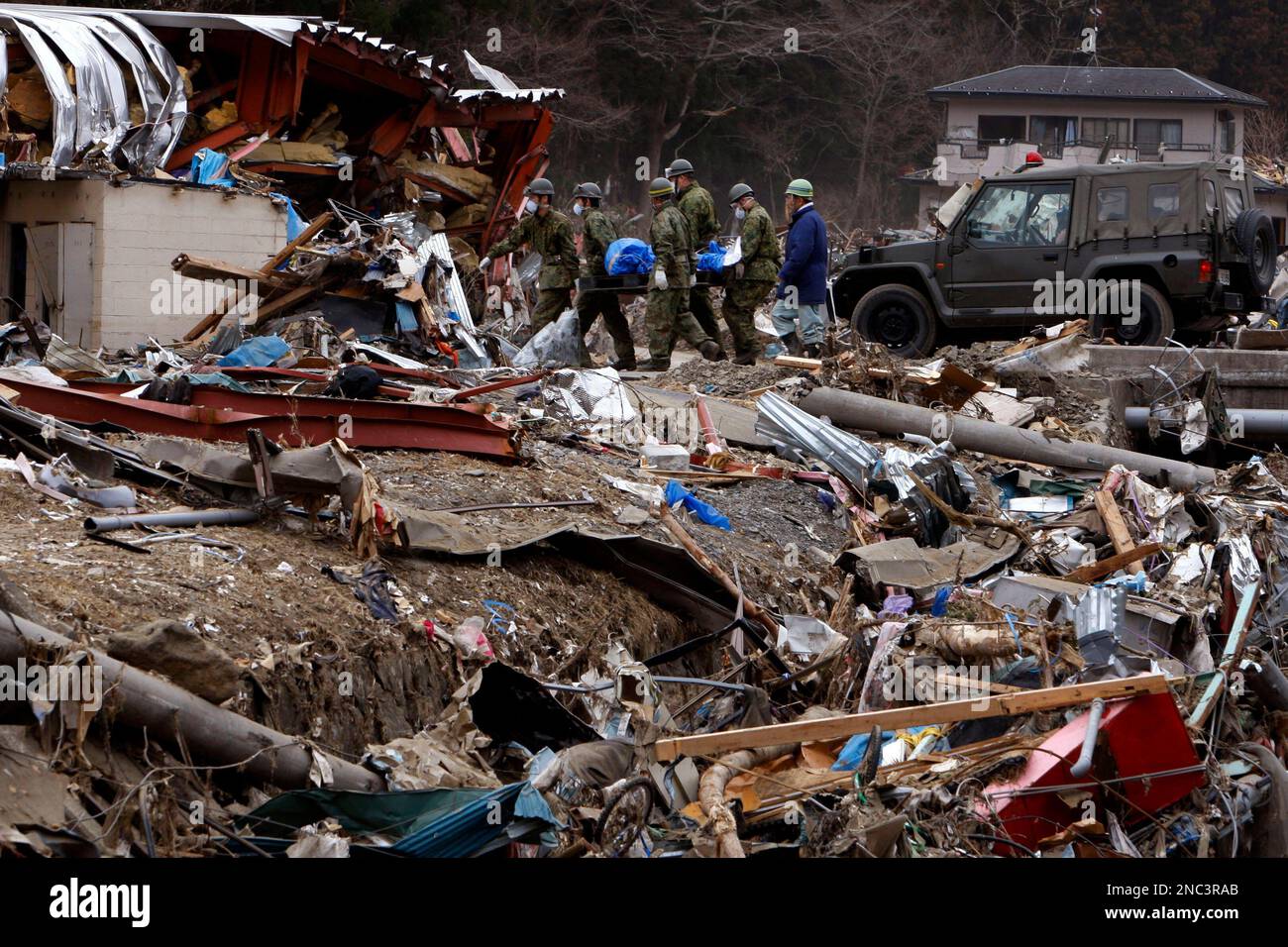 Members of Japan Self-Defense Force carry the body of a tsunami victim ...