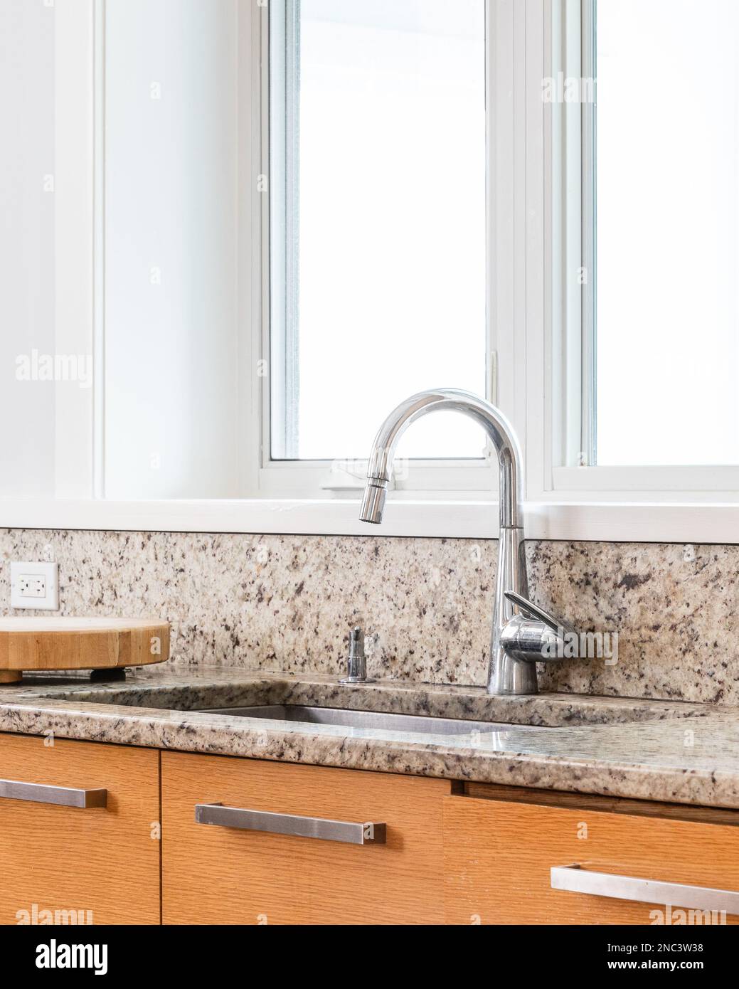 Detail shot of a sink in a luxury kitchen with a chrome faucet, light ...