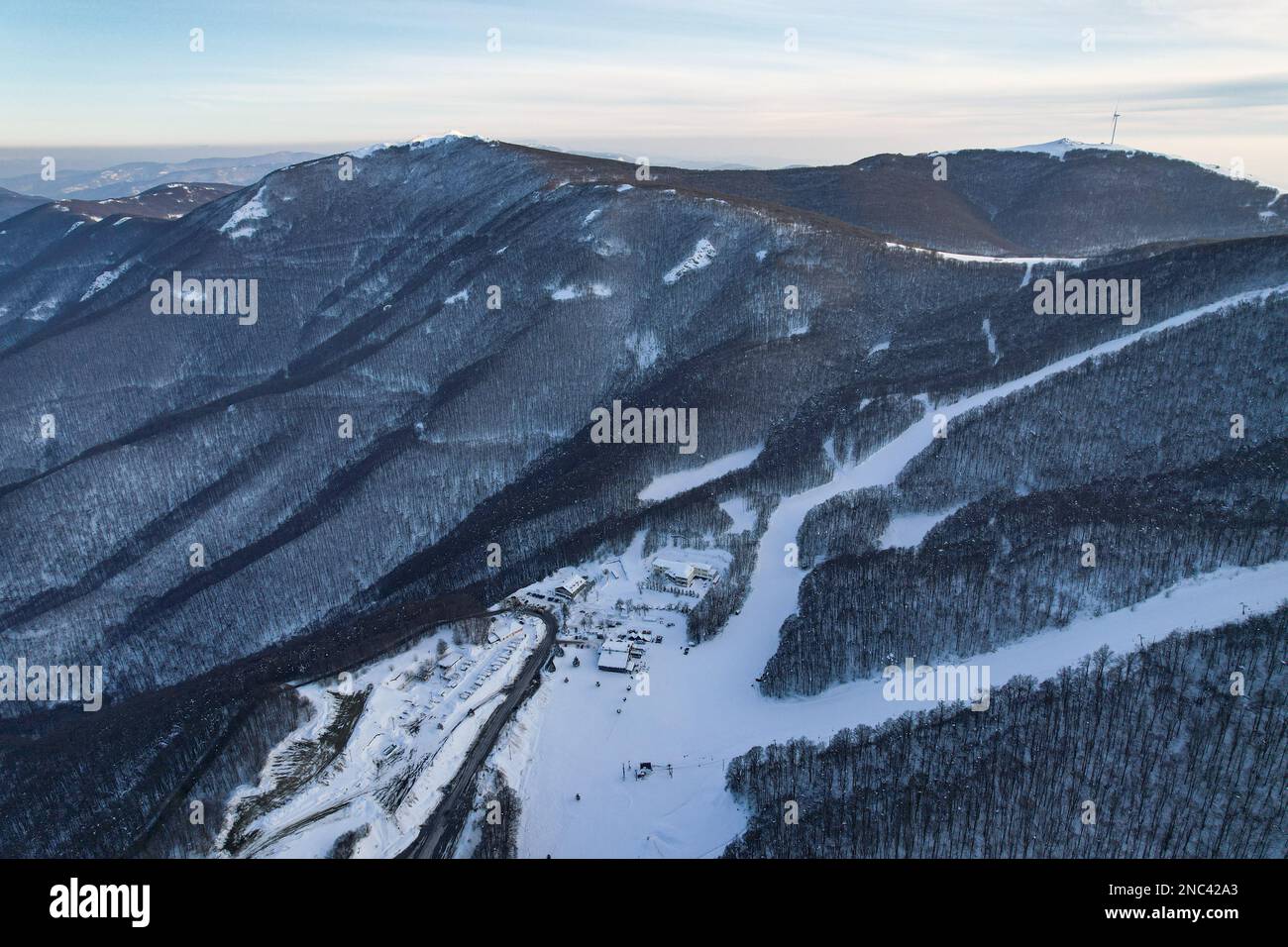 An aerial view of snow covered mountain landscape with dense trees ...