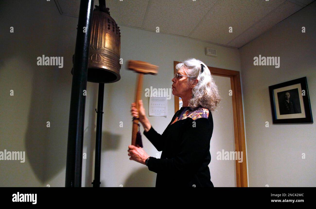 Mary Nabor rings a kansho bell to begin a seventh day memorial service ...