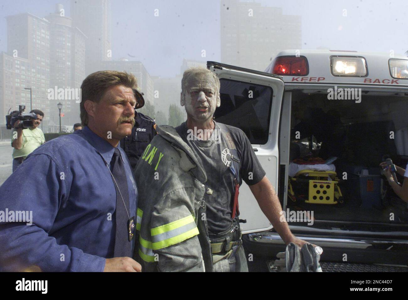A fireman is covered in debris after the collapse of the twin towers of ...