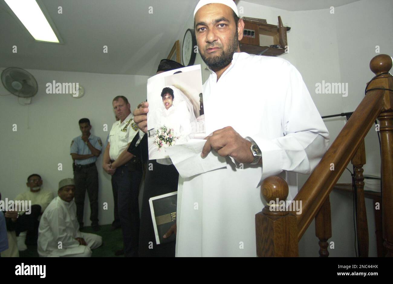 In this September 14, 2001 photograph, a man poses with a picture of a ...