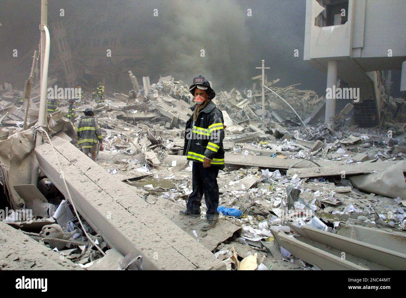 Firefighters walk through the rubble in the aftermath of the September ...