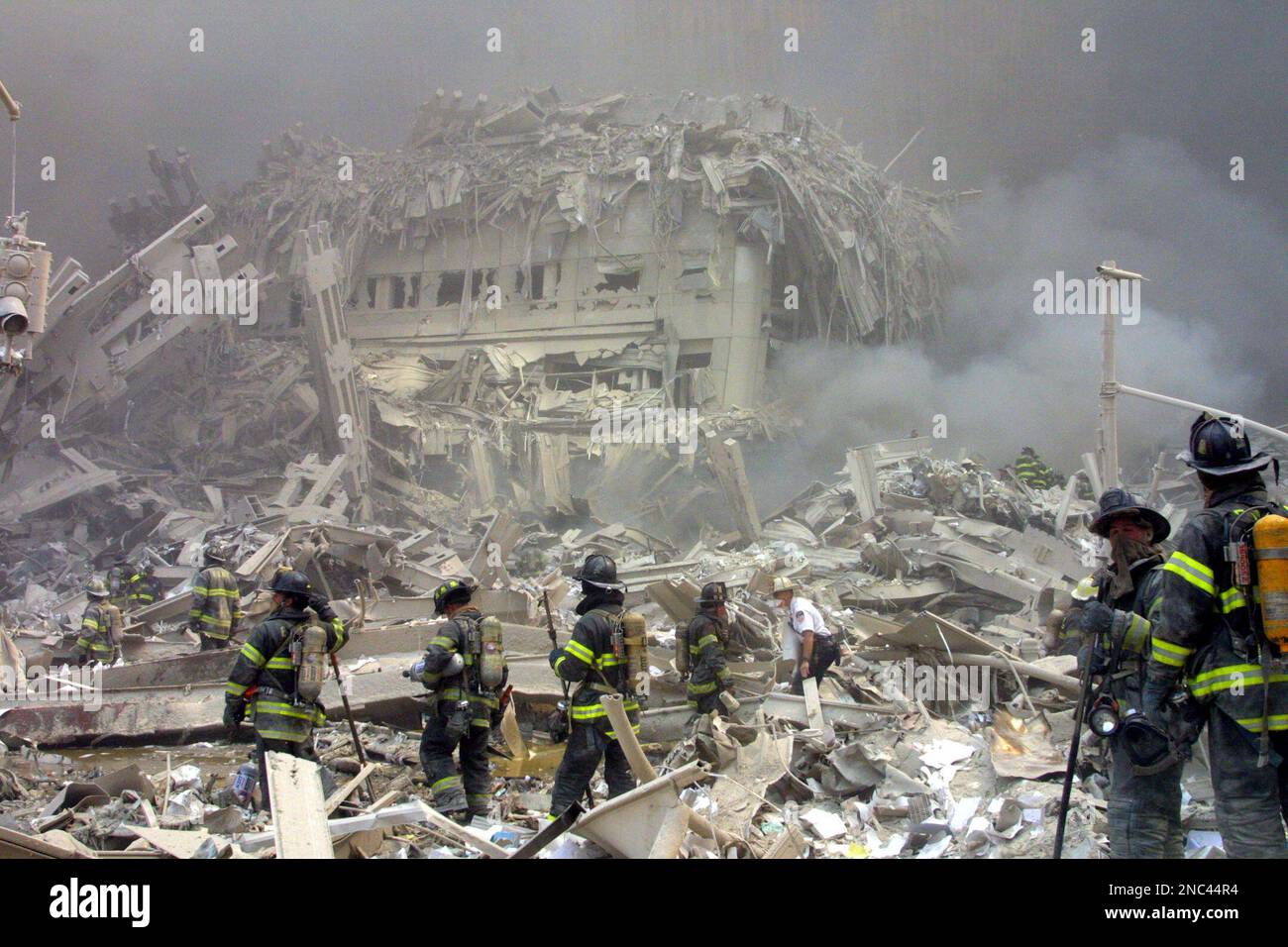 Firefighters walk through the rubble in the aftermath of the September ...