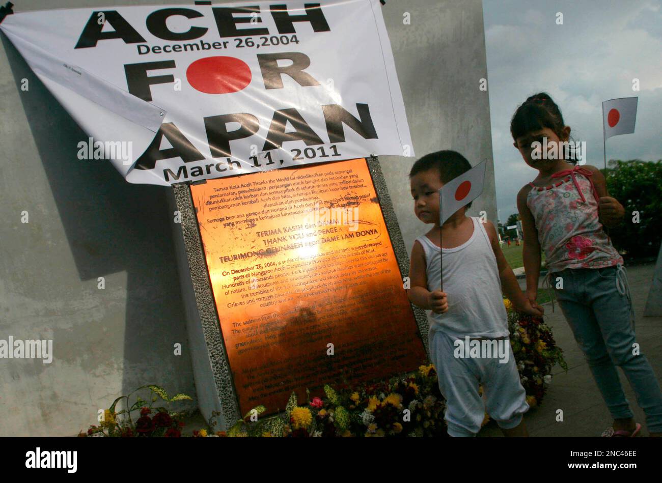 Acehnese children hold Japanese flags during a prayer for the victims ...