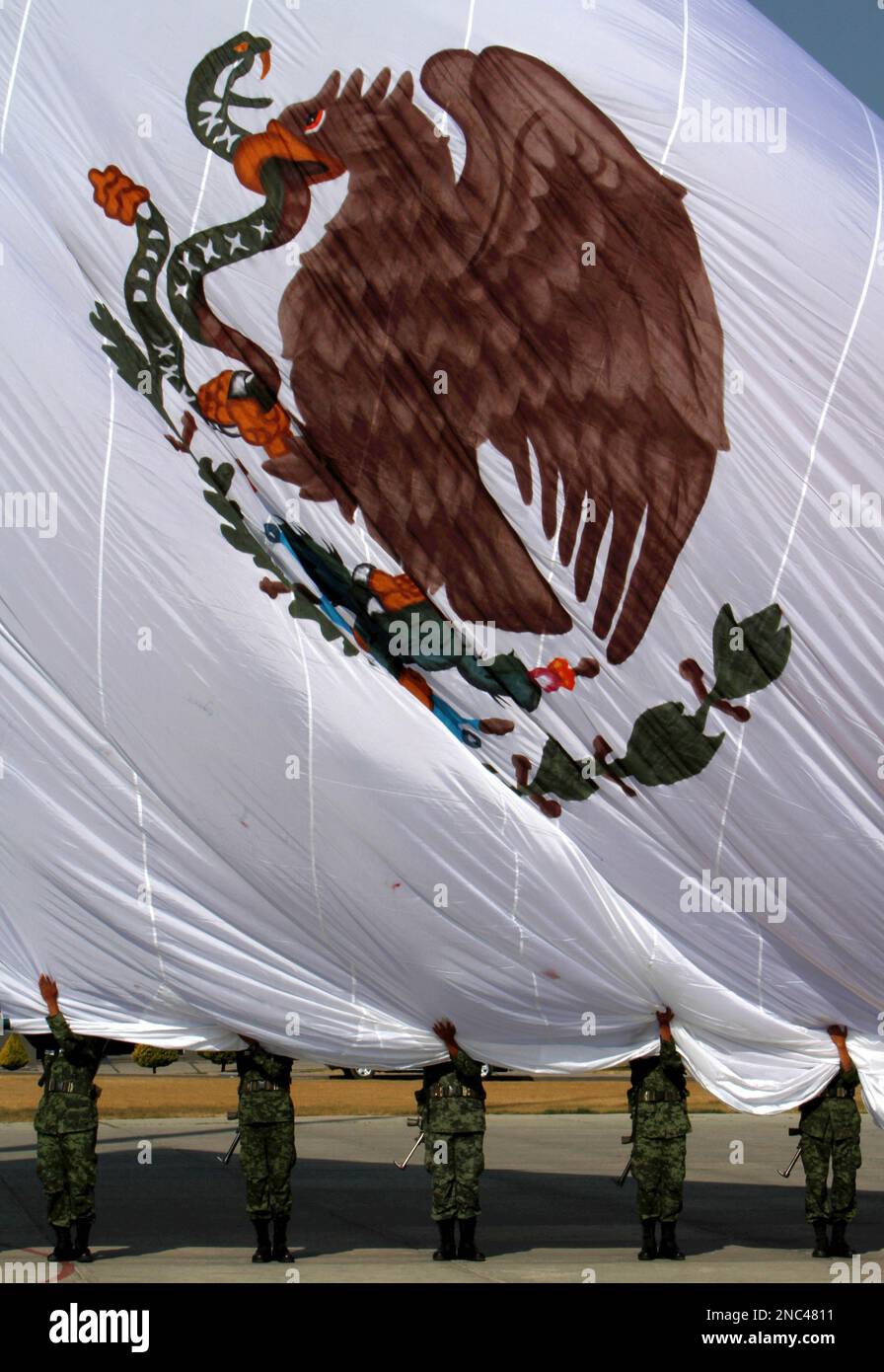 Mexican army special forces soldiers unfold a Mexican flag prior an ...