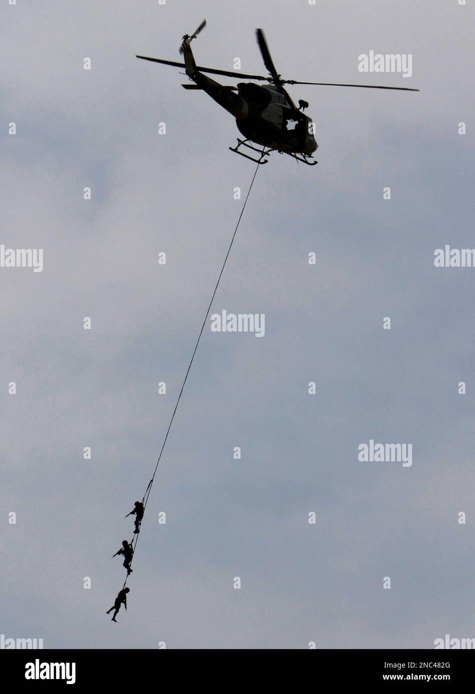 Mexican army special forces soldiers hang from a helicopter during an ...