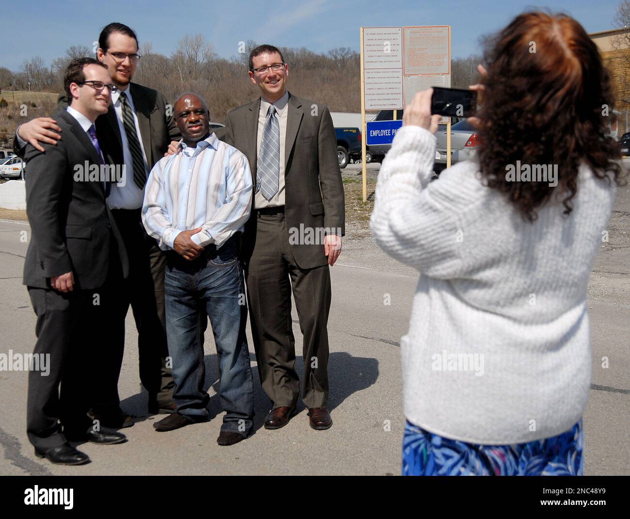 Eric Caine, center, poses for a photograph with his legal team, from ...