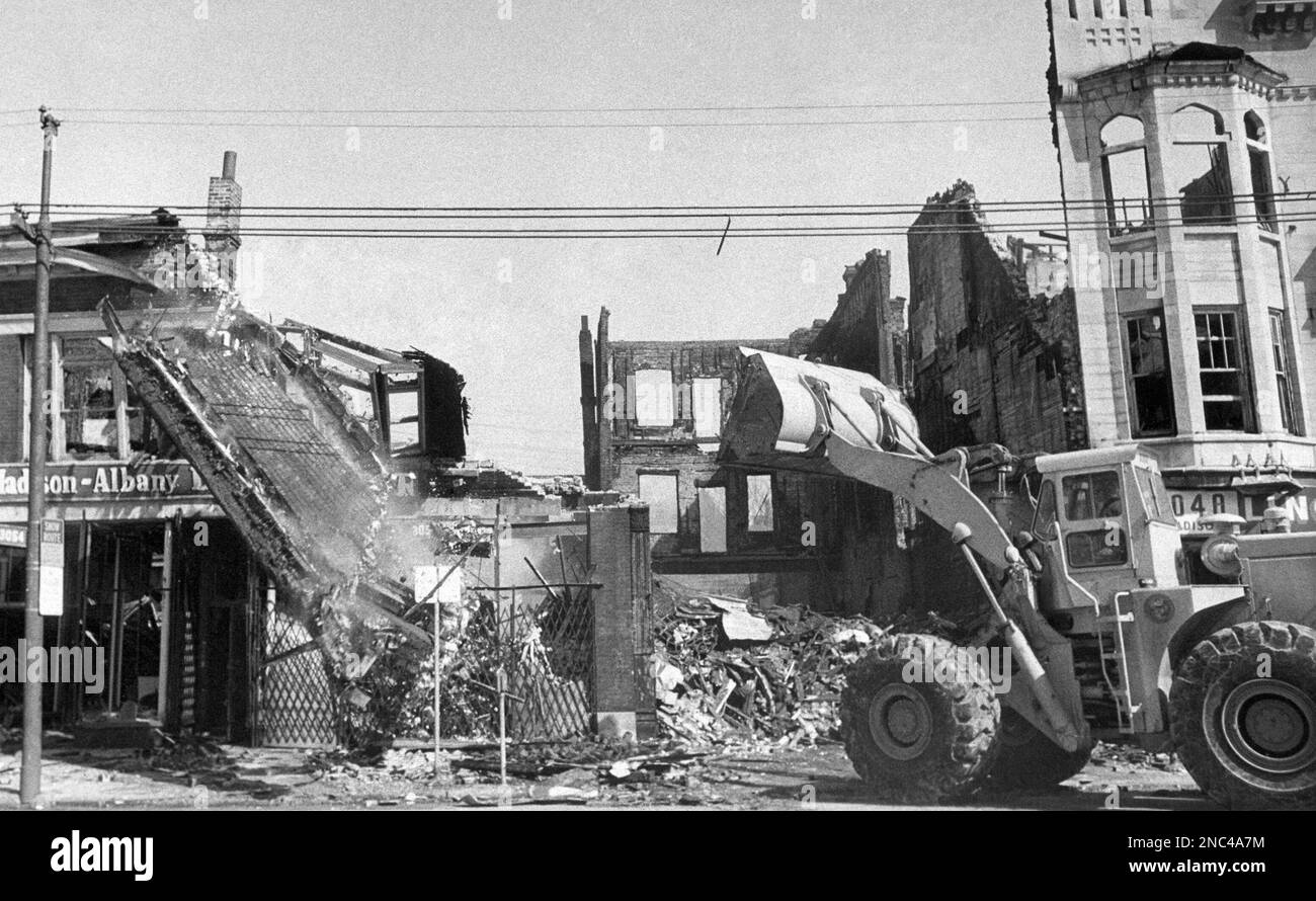 Front loading machine knocks down fire-ruined building walls in West ...