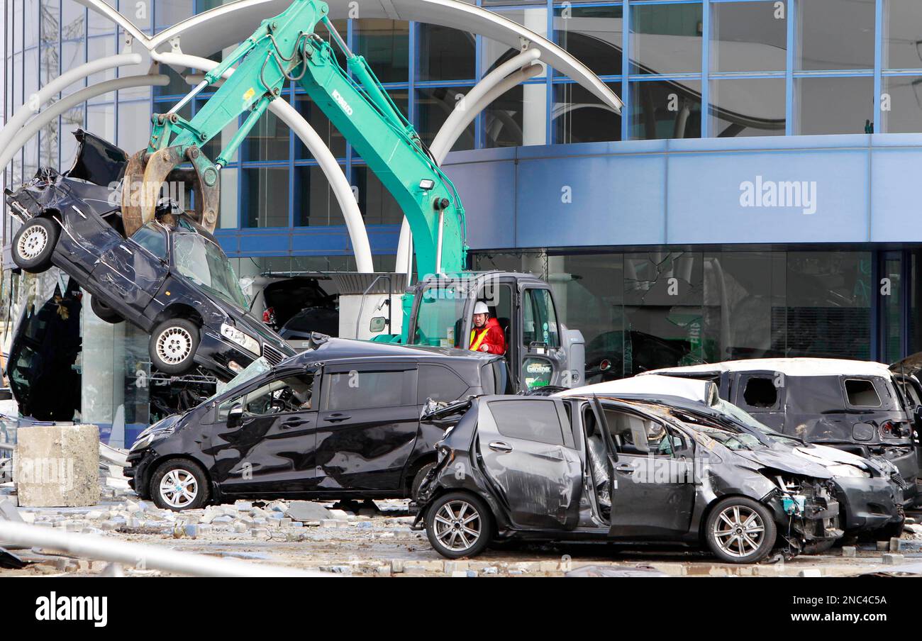 A wrecked car is pulled from a building following the March 11 ...