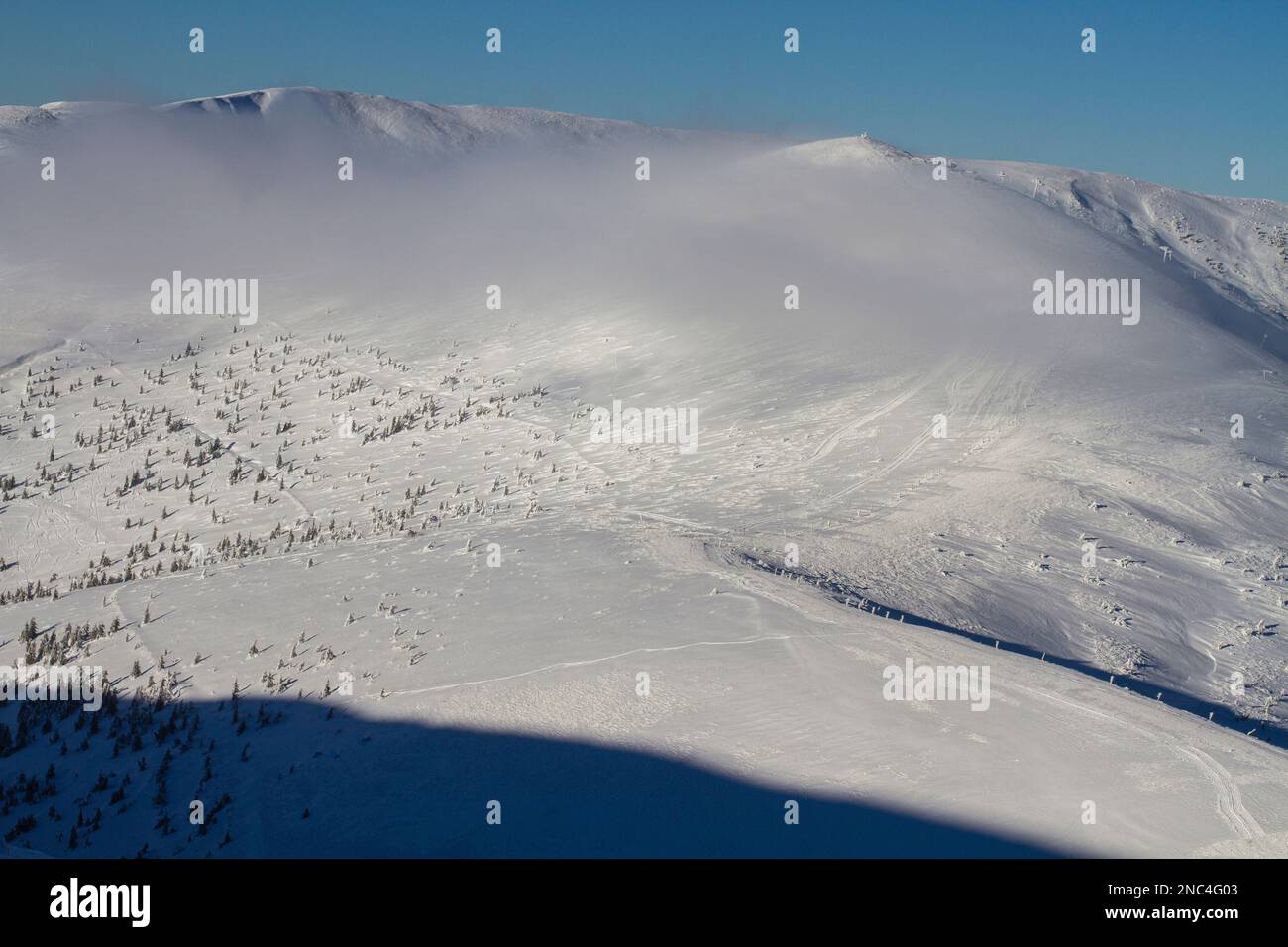 The fog covers the winter mountain, the mountain is covered with lifts ...