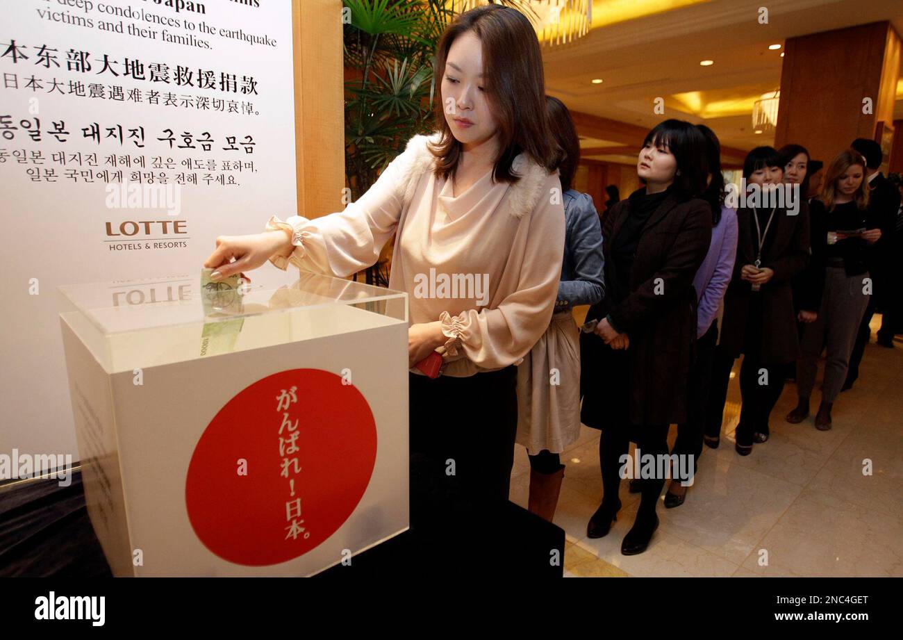 Employees of Lotte Hotel queue up to drop their donation into a box during a fund raising ...