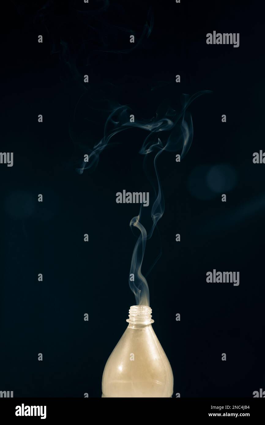 Moving smoke coming out of a plastic bottle. Isolated on black ...