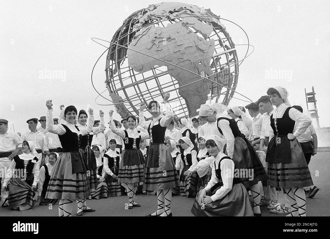 Dancers pose in front of the Unisphere at the New York’s World’s Fair ...
