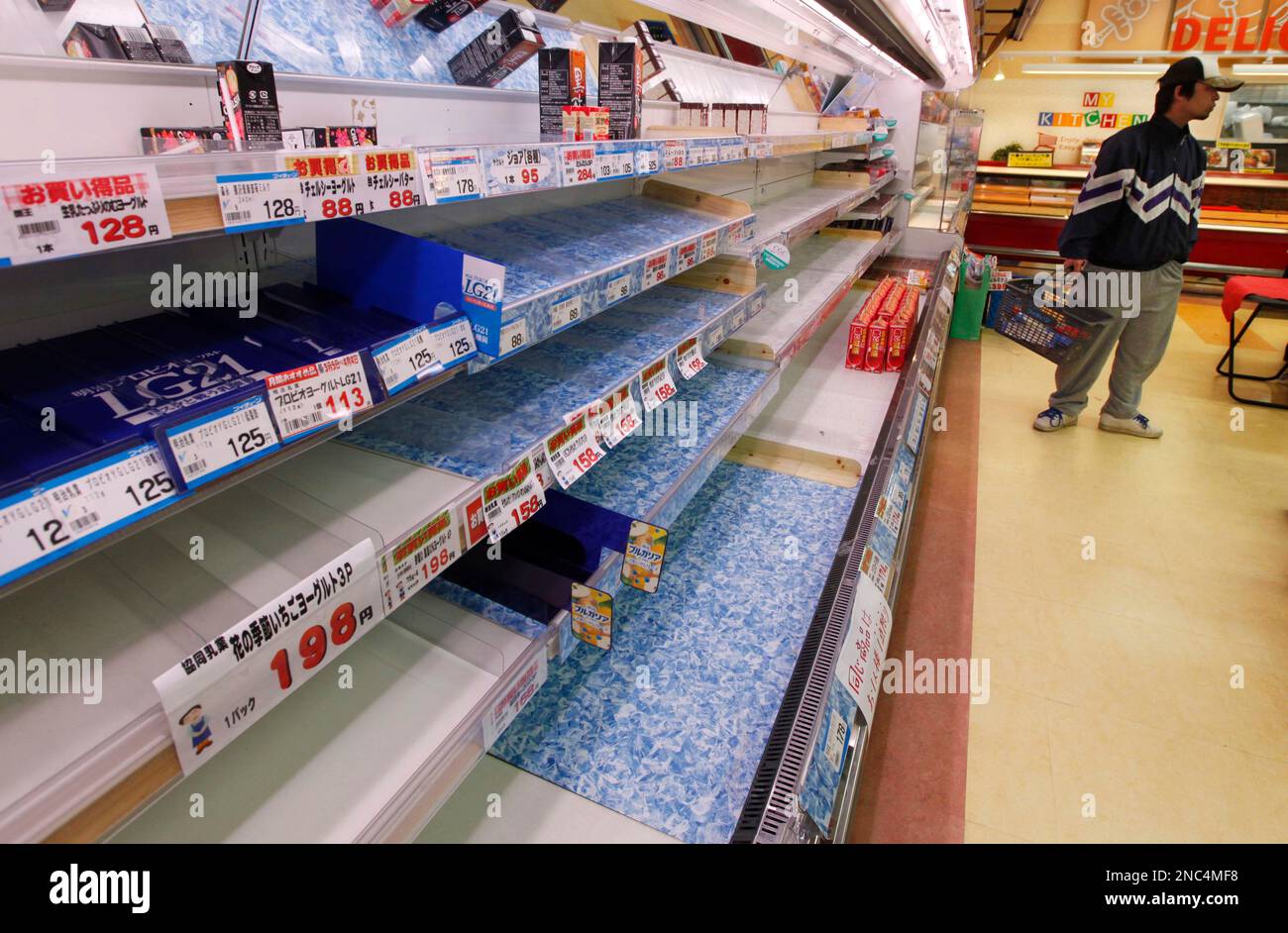 A shopper stands near the empty shelves in a supermarket in Moriyama ...