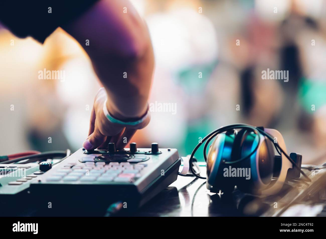 DJ plays music on summer festival. Disc jockey using midi controller ...