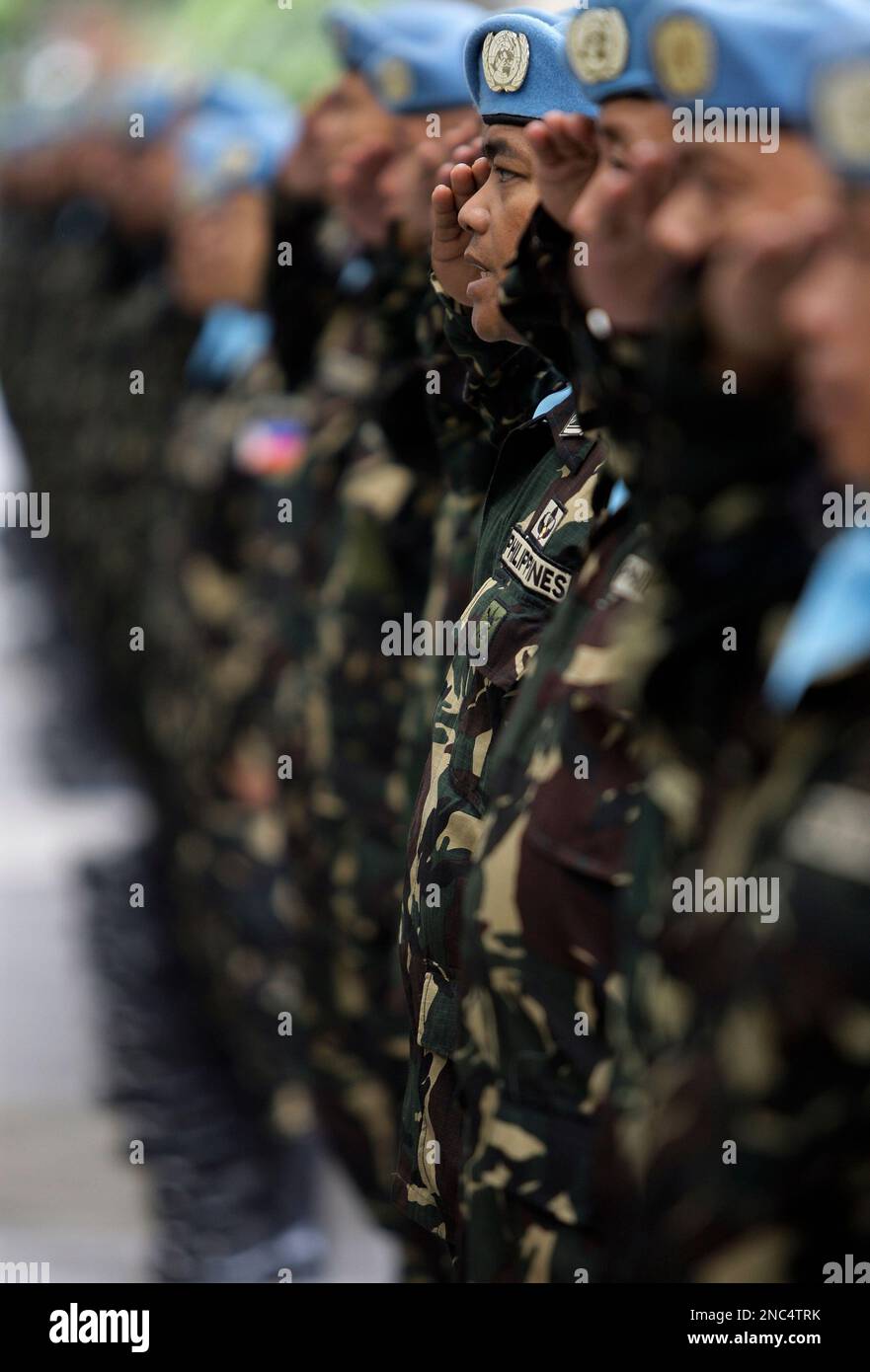 Filipino troopers salute during a send-off ceremony for the 15th ...