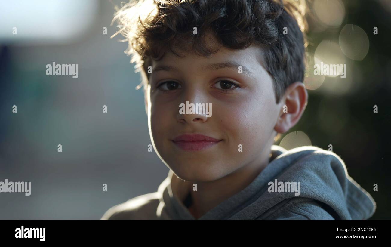 Portrait of a happy young boy close up face looking at camera smiling ...