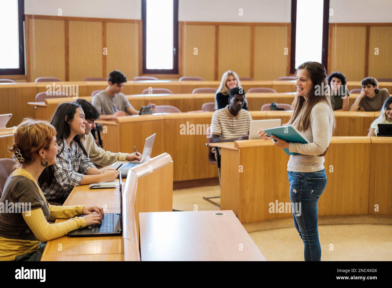 University professor explaining to her students in the main classroom ...