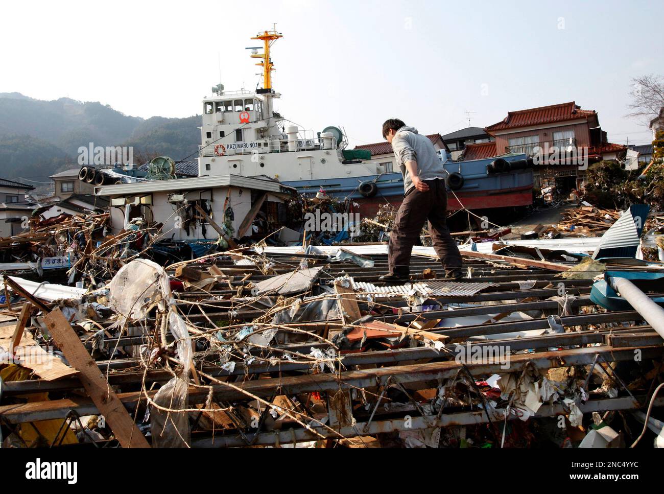 A man searches through the rubble in Ofunato, Iwate Prefecture ...