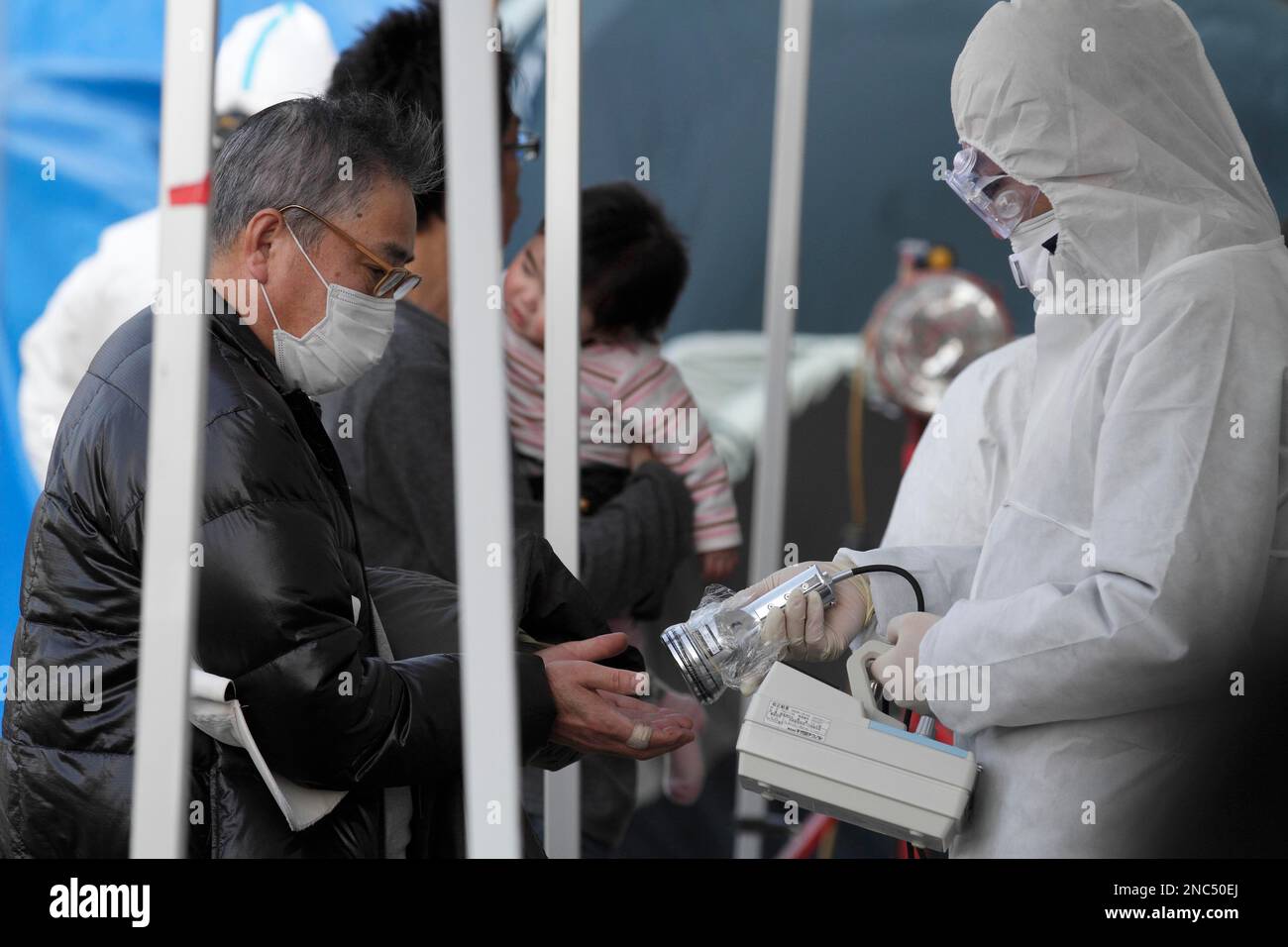 An official scans a man for radiation at an emergency center Sunday ...