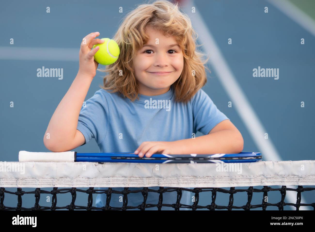 Kid with tennis racket and tennis ball playing on tennis court. Sport ...