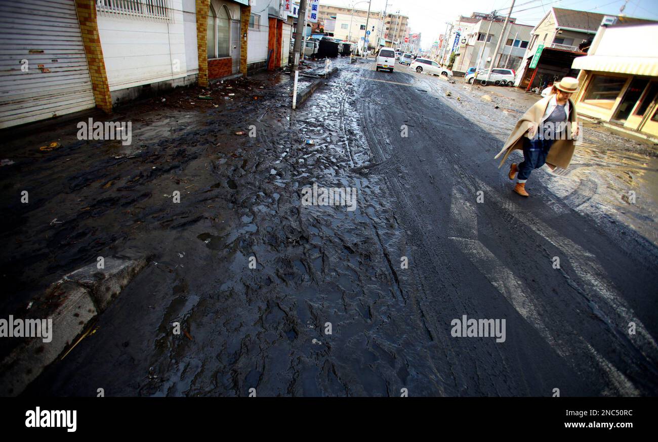 A sole lady walks on a street and inspects the aftermath of a massive ...
