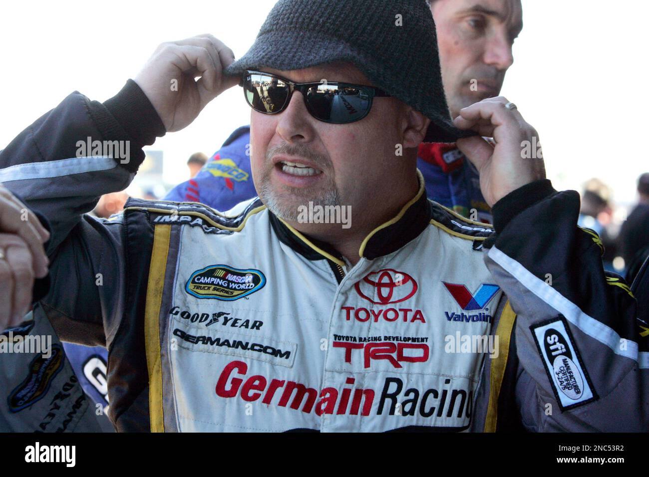 Nascar driver Todd Bodine put on his hat as he gets out of his truck ...