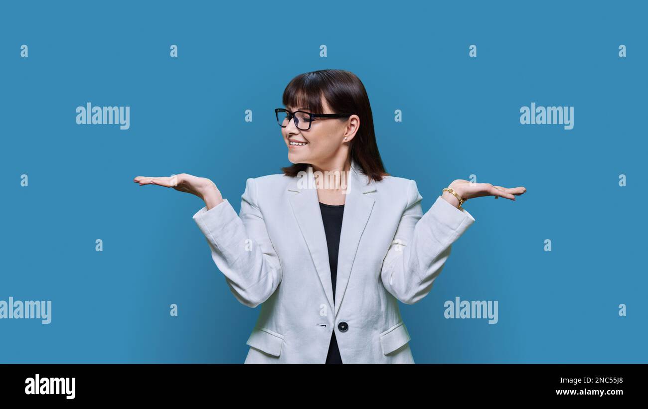 Business woman holding two hands with empty open palms on blue ...
