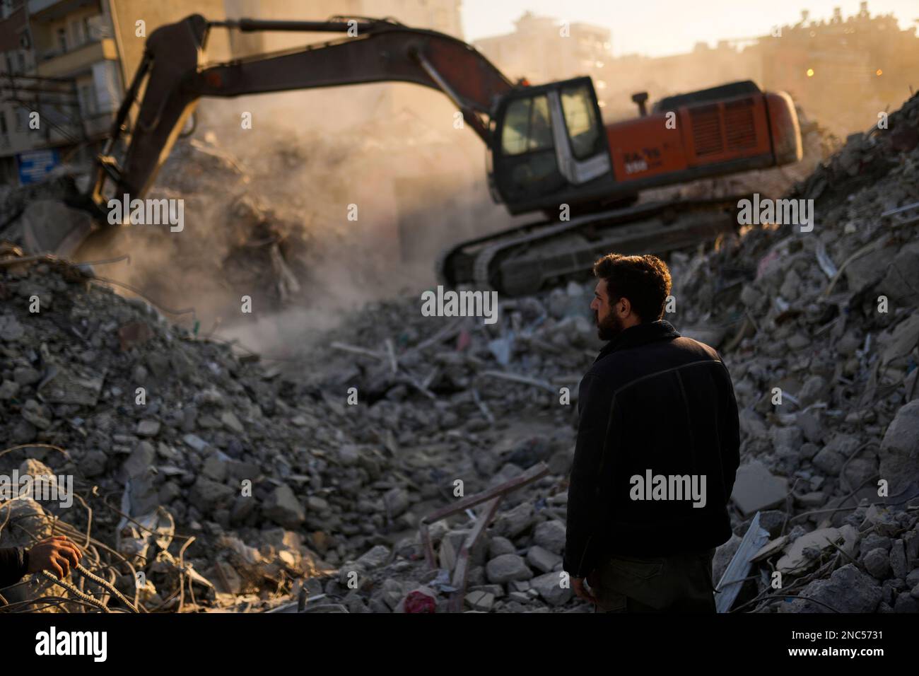 Sekip Kaan Ciplak, 29, watches an excavator working in a destroyed ...