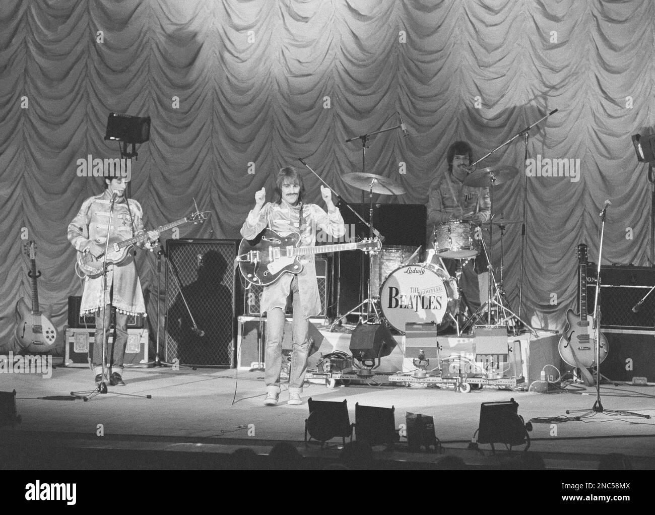 Members of the Bootleg Beatles musical group shown near a church in the ...