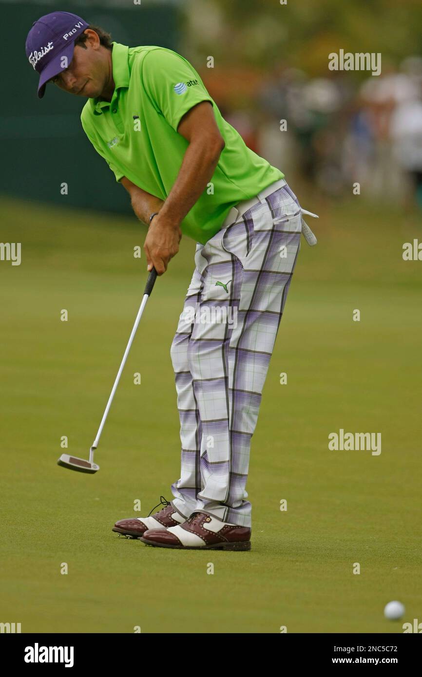 Max Alverio, of Puerto Rico, follows through his put in the 18th hole ...