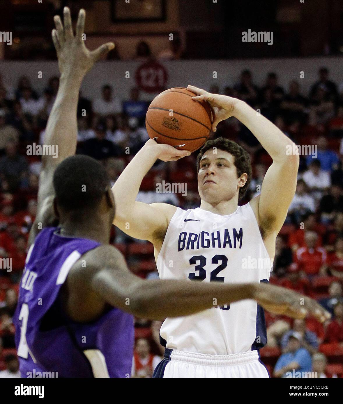 BYU's Jimmer Fredette puts up a three point shot over TCU's J.R. Cadot ...