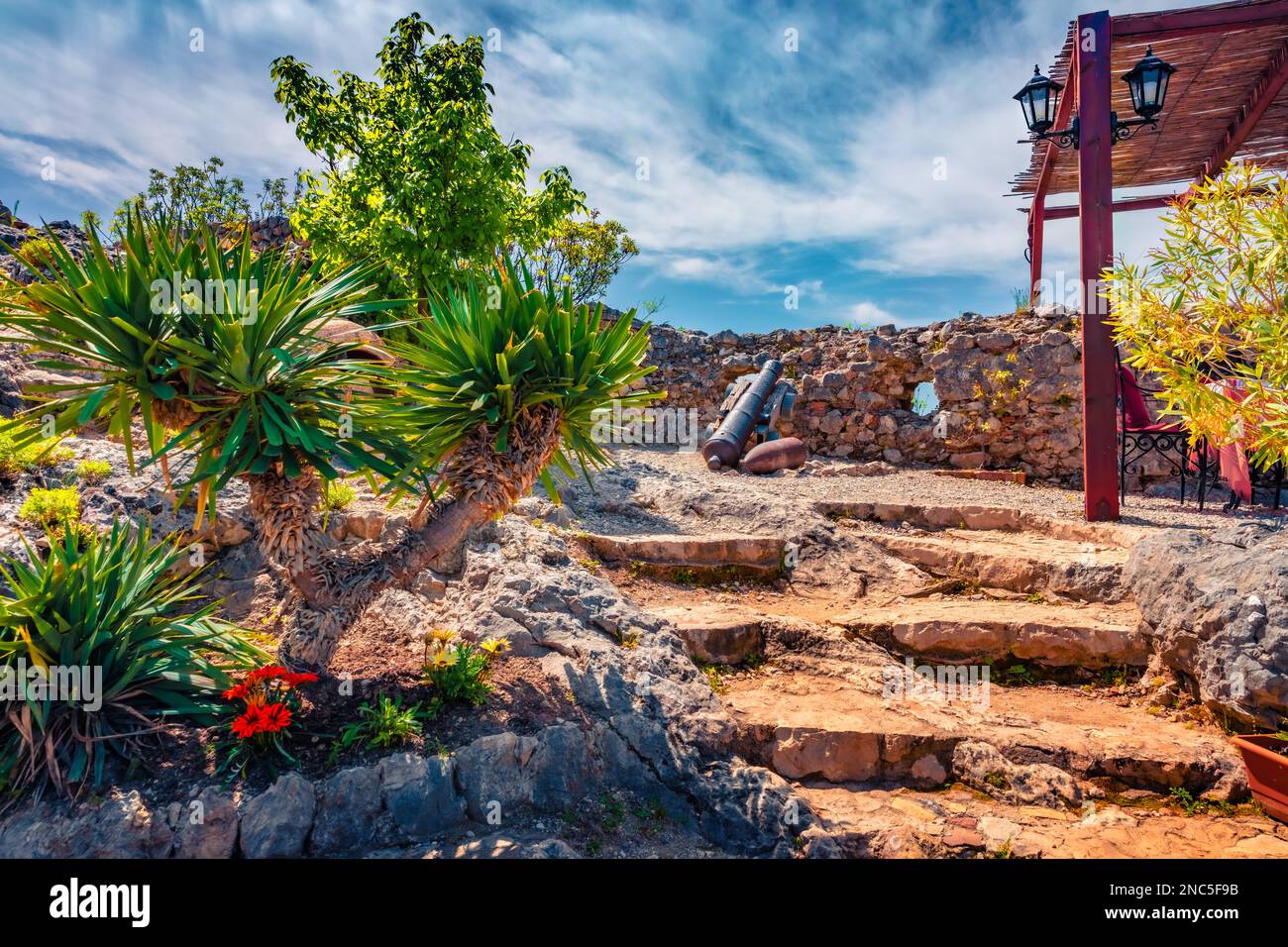 Old cannon on the stone wall in Petrela Castle. Picturesque spring ...