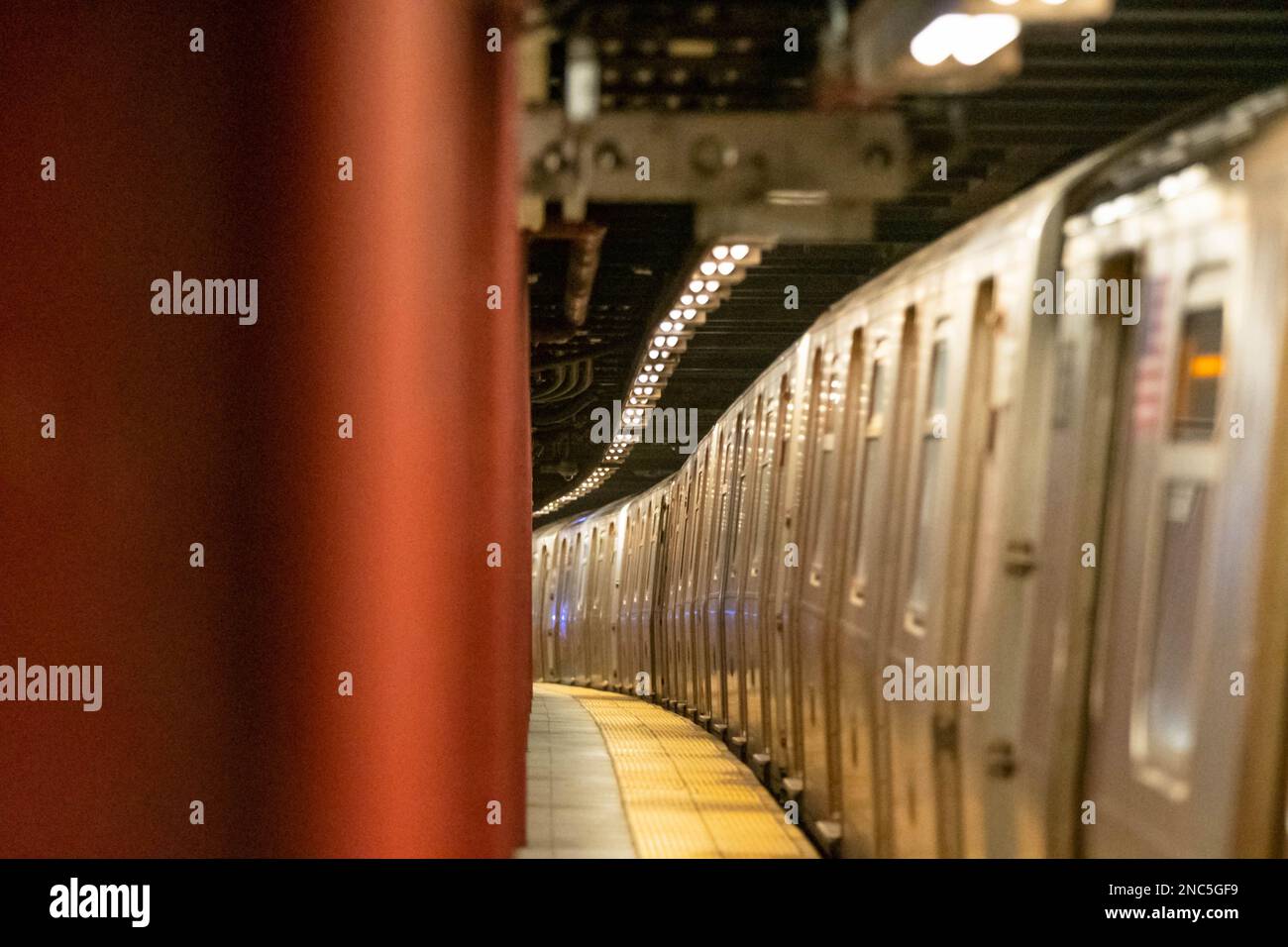 A golden train car in a subway station lit by electric bulbs Stock ...