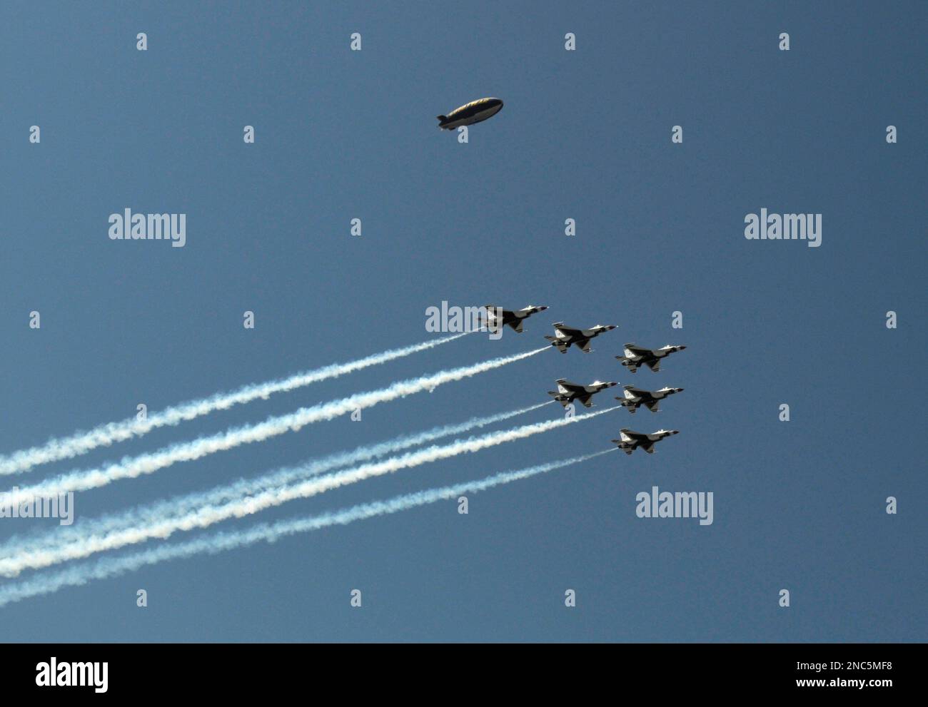 The U. S. Air Force Thunderbirds fly past the Goodyear blimp over the ...