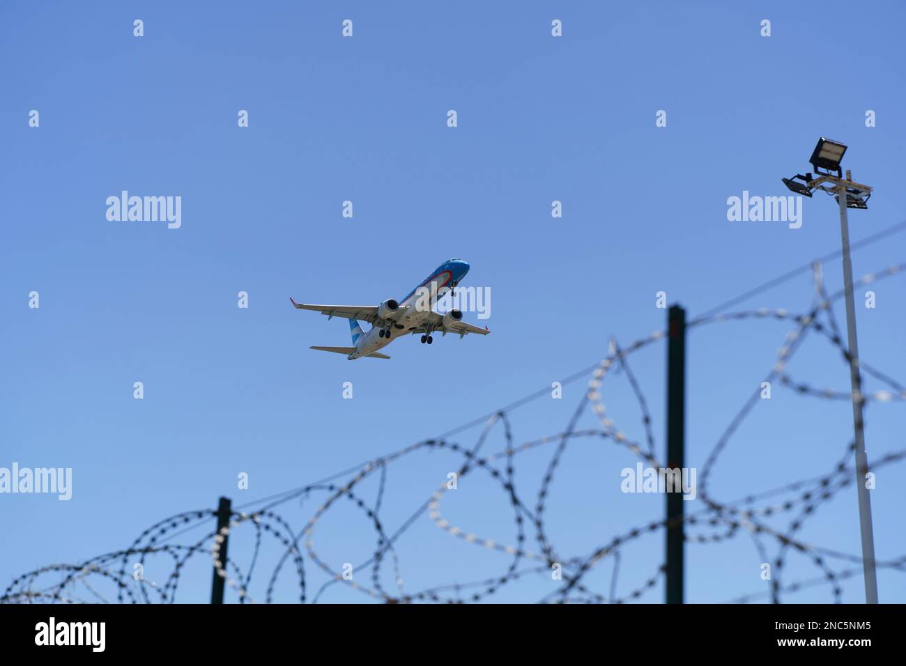Plane taking off against the background of the fence and the border of ...