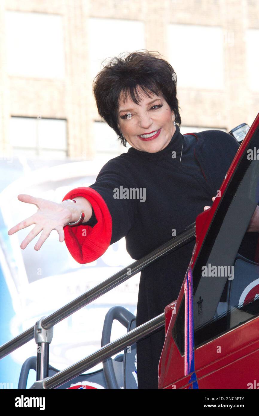 Liza Minnelli waves to fans from a double-decker Gray Line tour bus ...
