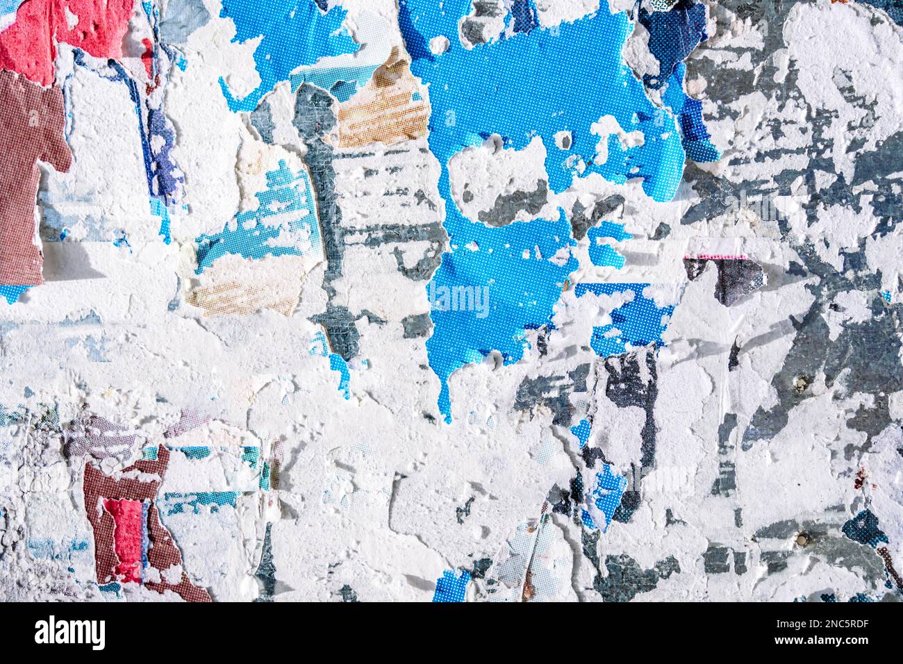 Torn paper collage background on an old poster on a street wall ...